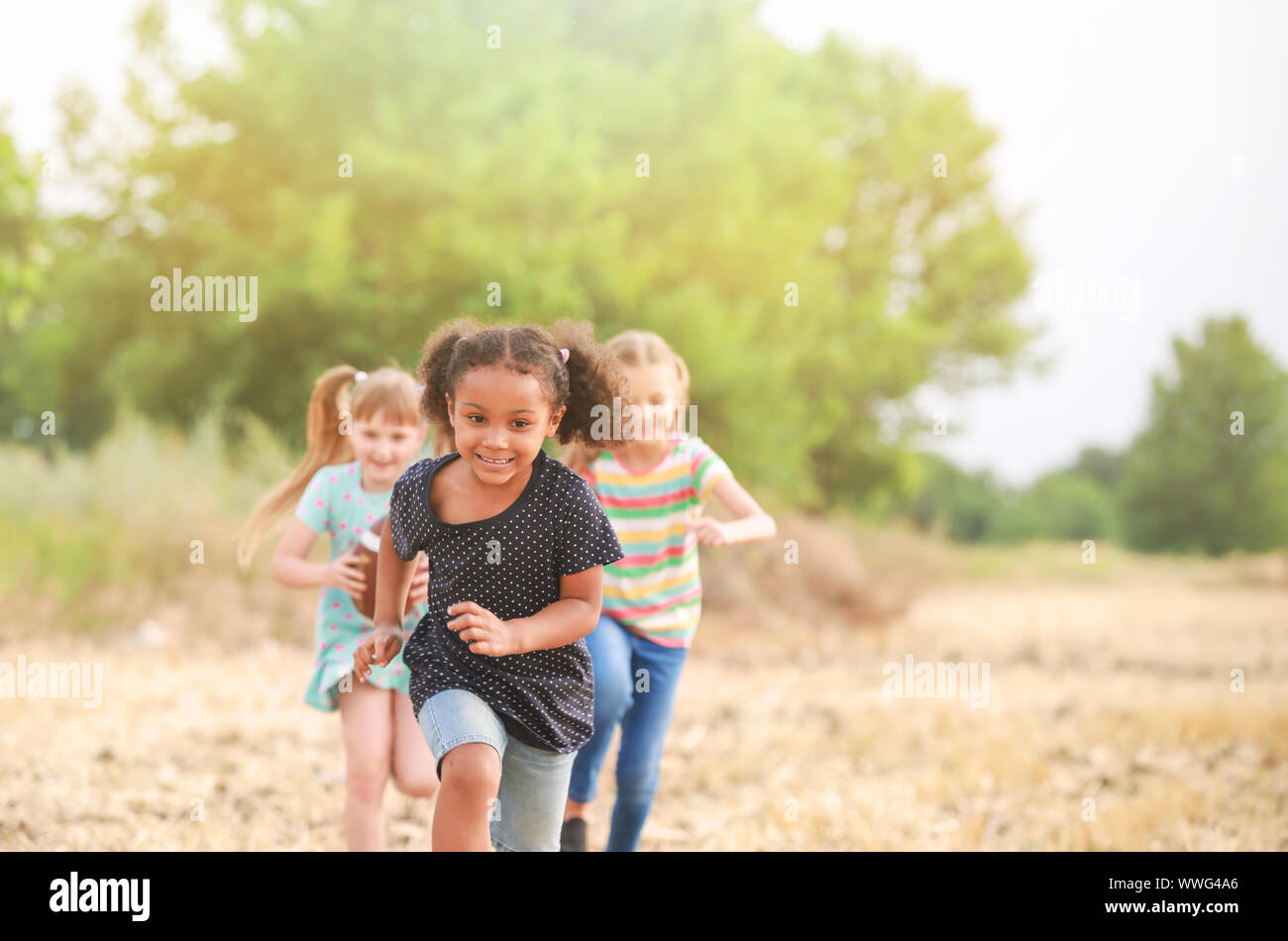 Cute little children running outdoors Stock Photo - Alamy