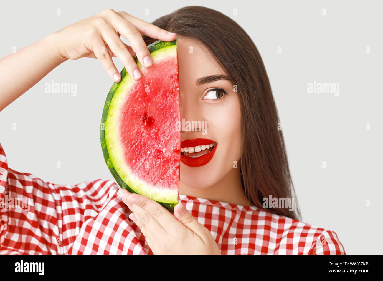 Beautiful young woman with slice of fresh watermelon on light ...