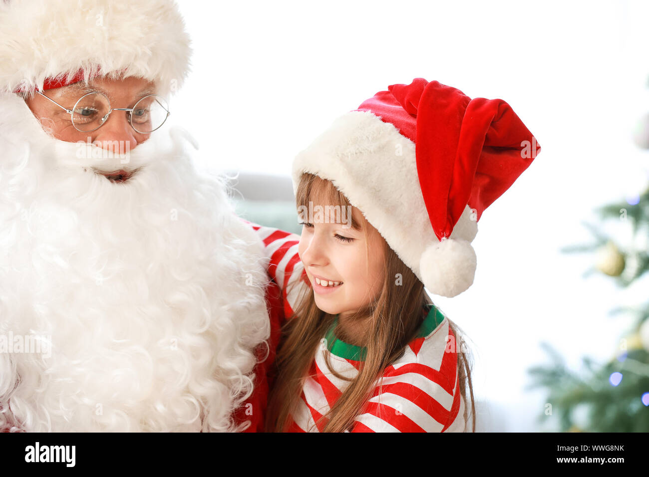 Santa Claus and little girl in room decorated for Christmas Stock Photo ...