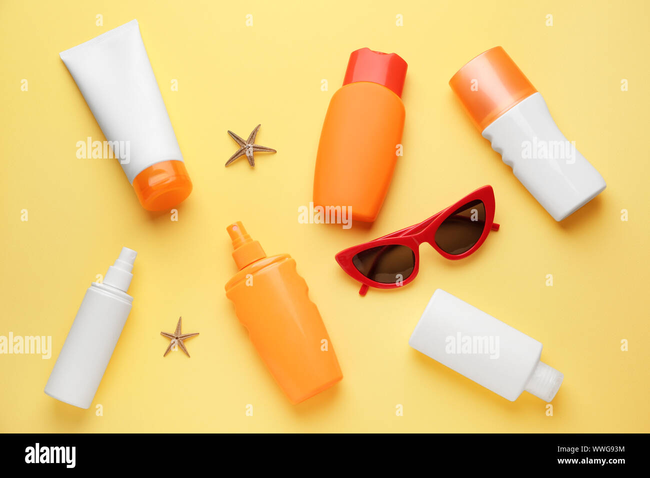 Different sun protection creams and sunglasses on color background ...