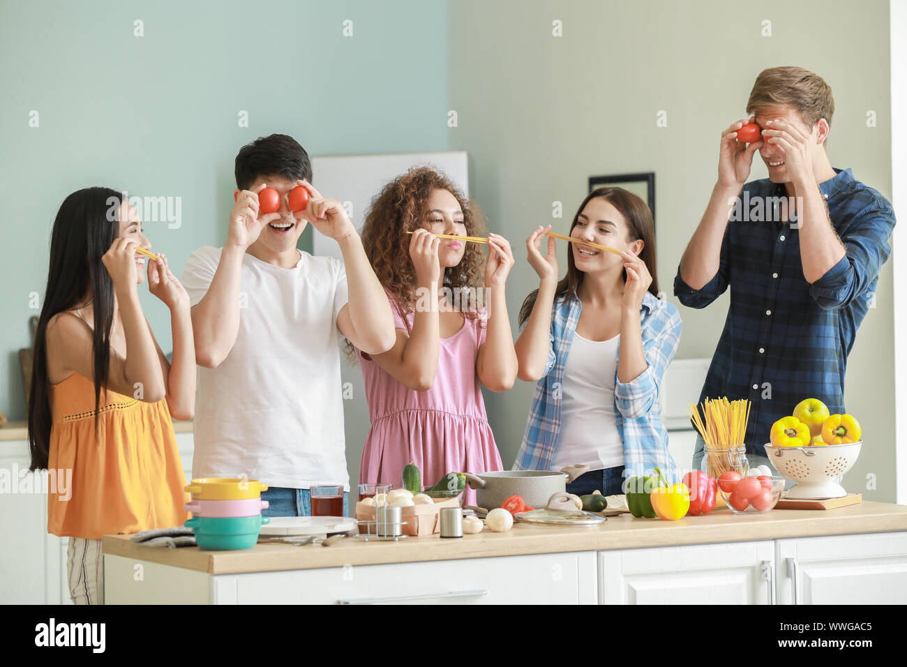 Happy friends having fun while cooking together in kitchen Stock Photo ...