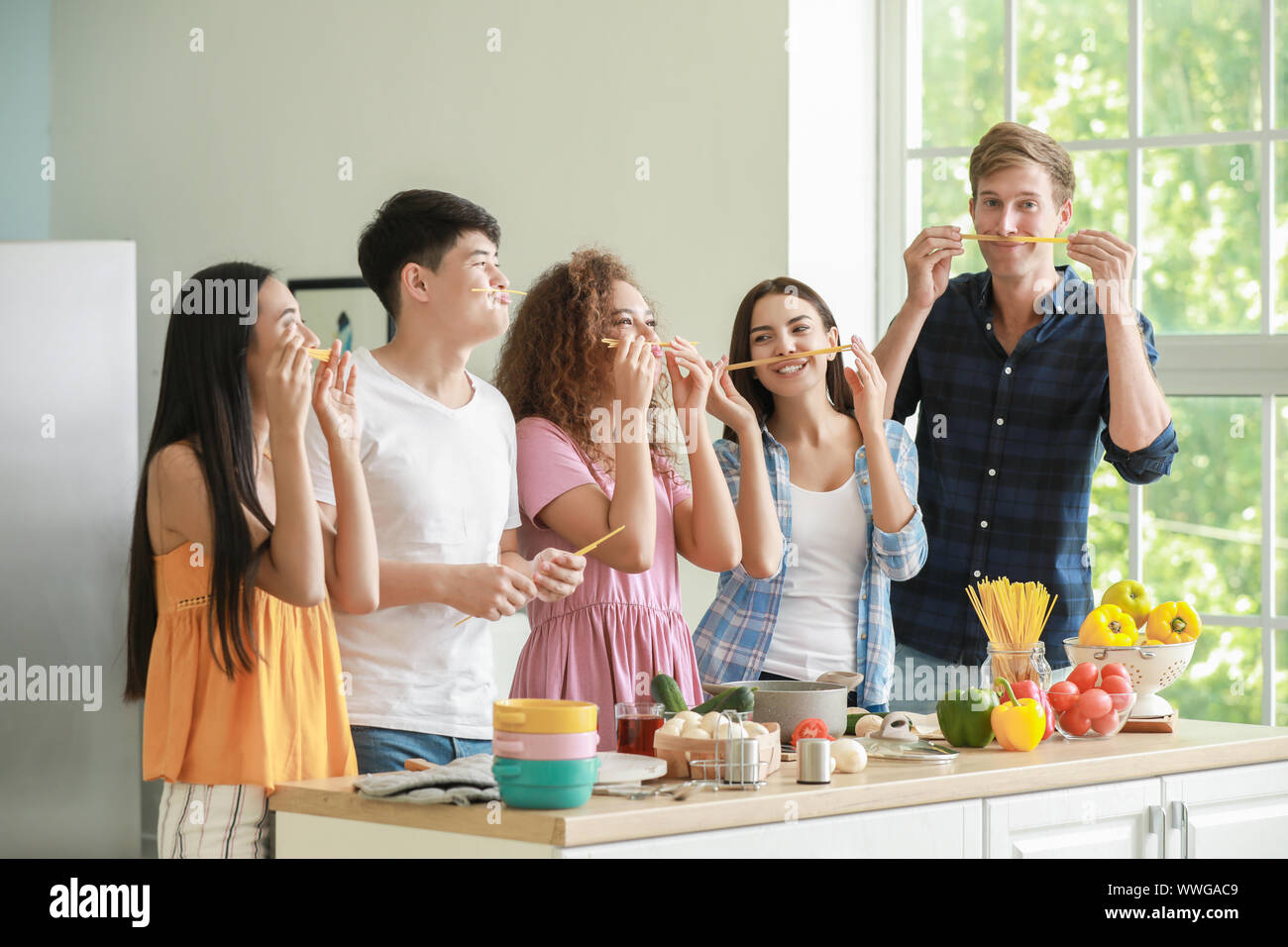 Happy friends having fun while cooking together in kitchen Stock Photo ...