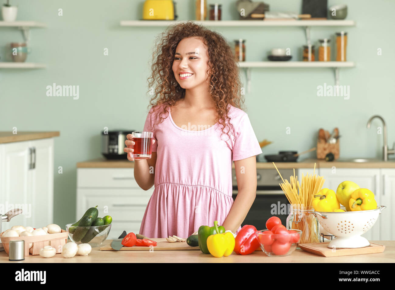 Beautiful African-American woman cooking in kitchen Stock Photo - Alamy