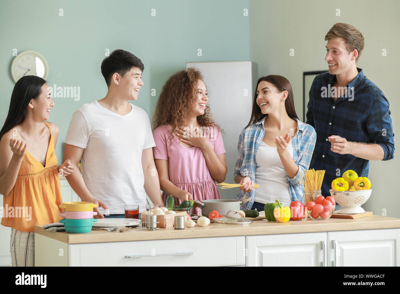Happy friends cooking together in kitchen Stock Photo - Alamy