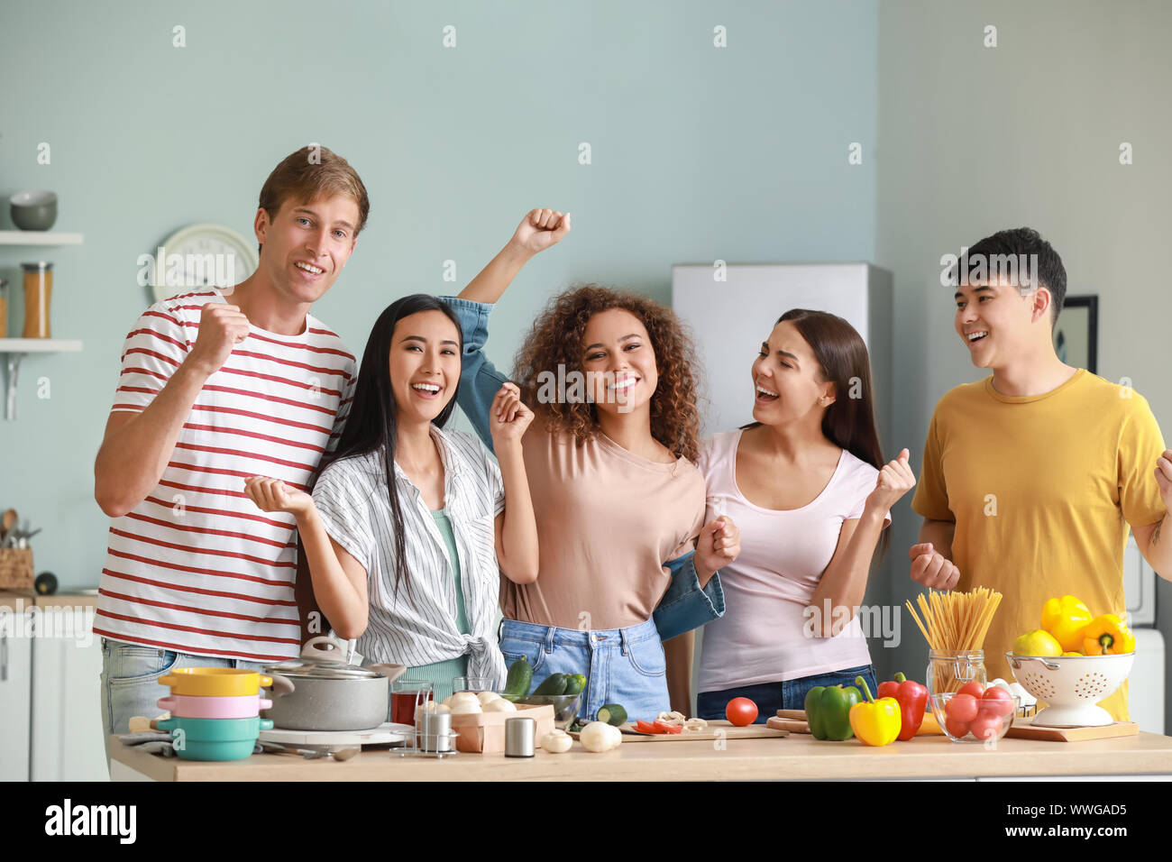 Happy friends cooking together in kitchen Stock Photo - Alamy
