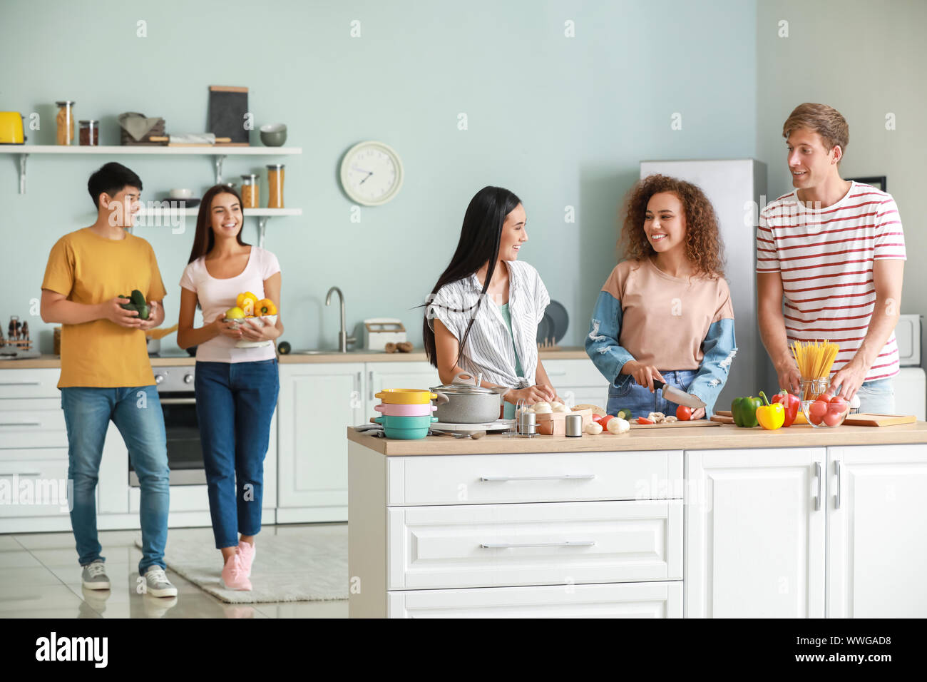 Happy friends cooking together in kitchen Stock Photo - Alamy