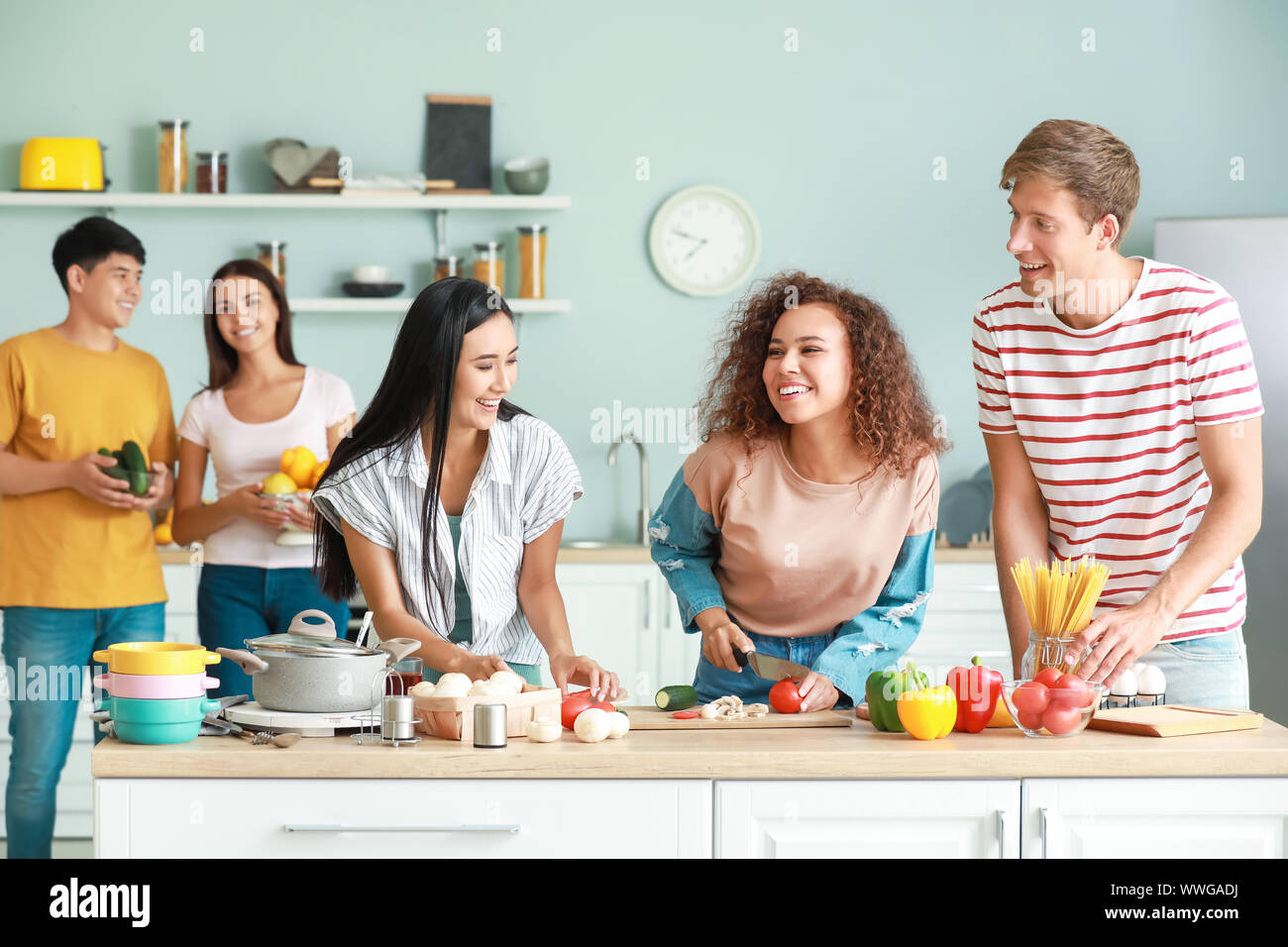 Happy friends cooking together in kitchen Stock Photo - Alamy