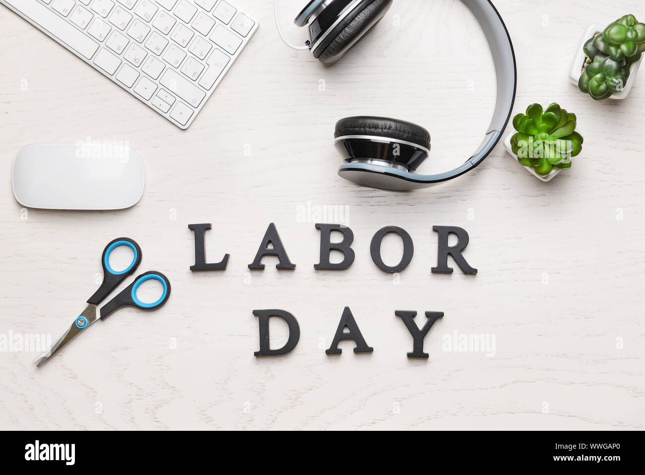 PC keyboard, mouse, headphones and text LABOR DAY on light background ...