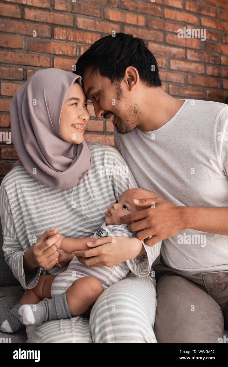 happy muslim parent with their newborn baby at the livingroom together ...