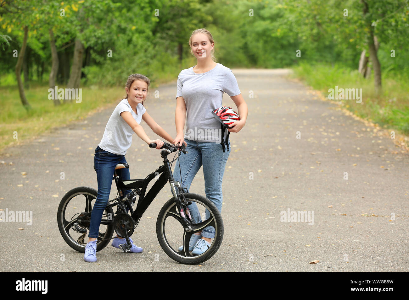 Woman and her little daughter with bicycle outdoors Stock Photo - Alamy