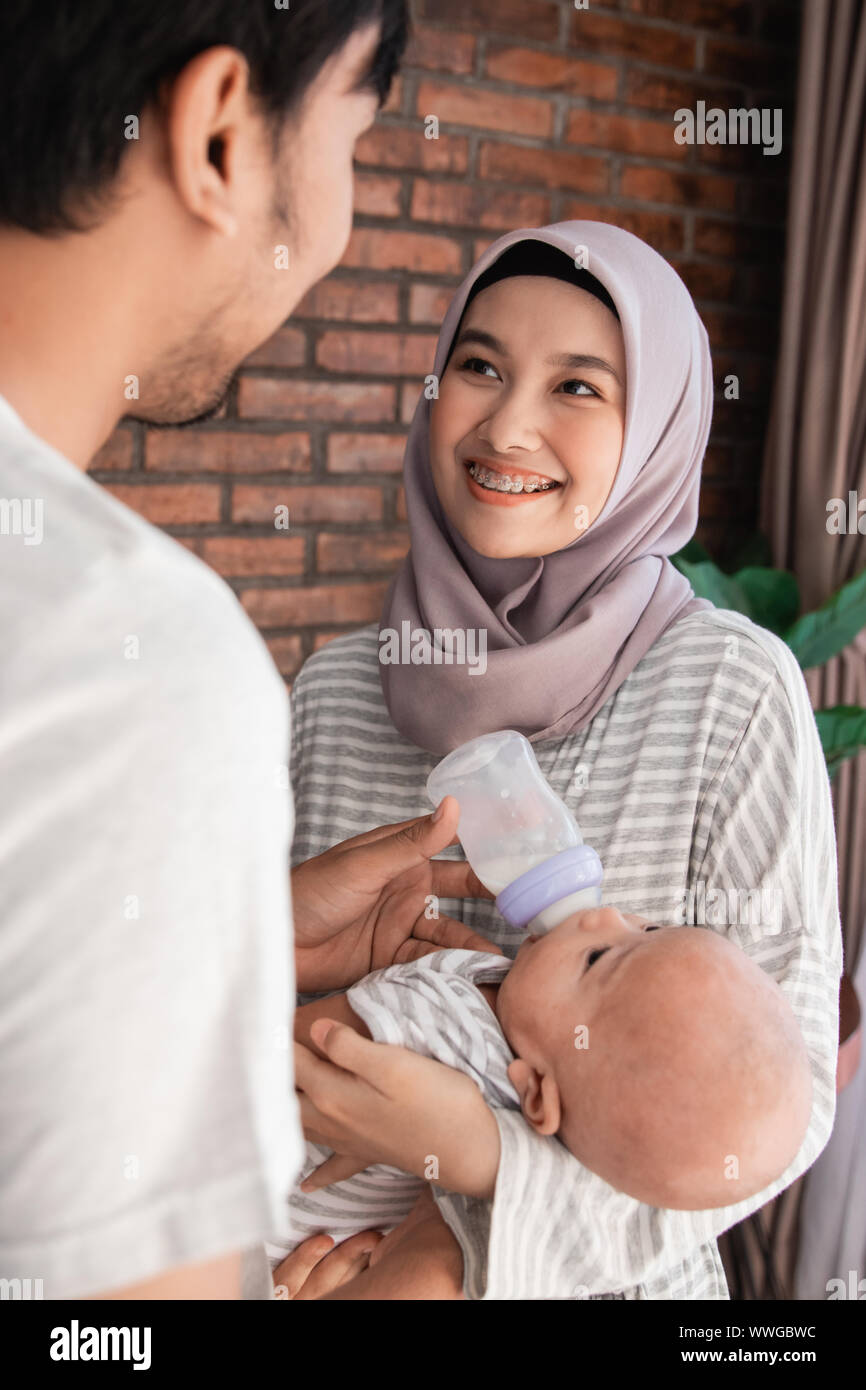muslim parent feed baby boy with milk on the bottle Stock Photo - Alamy