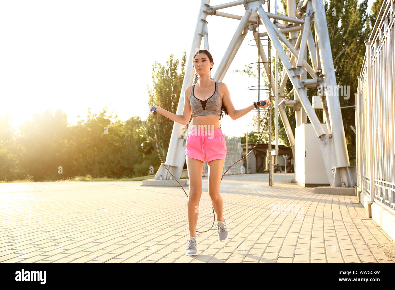 Sporty Asian woman jumping rope outdoors Stock Photo - Alamy