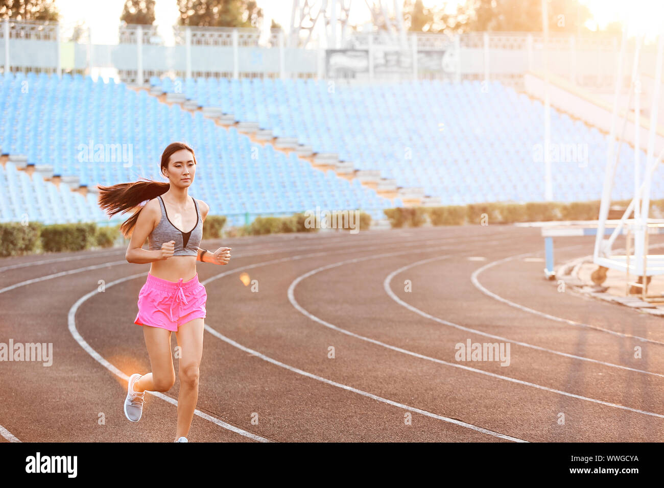 Sporty Asian woman running at the stadium Stock Photo - Alamy