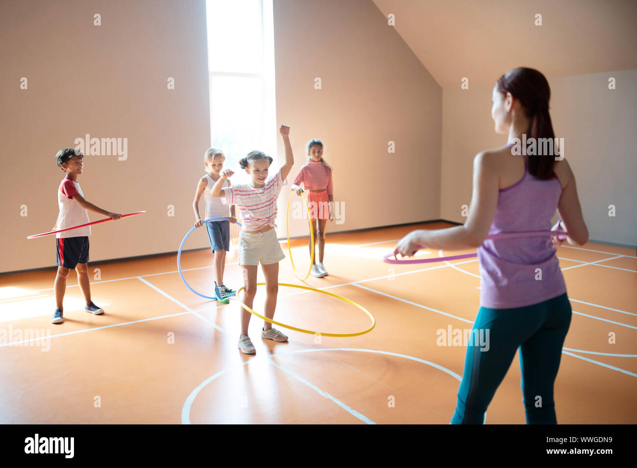 Children trying to roll hula-hoop at the PE lesson Stock Photo - Alamy