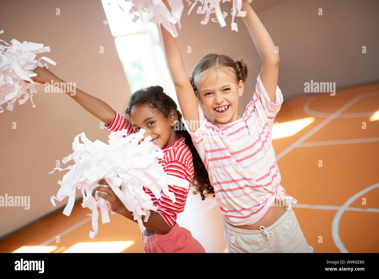 Girls wearing sport clothing laughing while practicing cheerleading ...