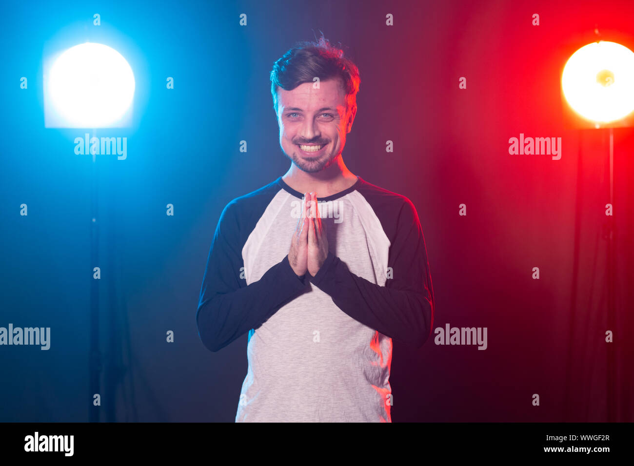 Portrait of man keeps palms together, has pleased expression. Glad ...