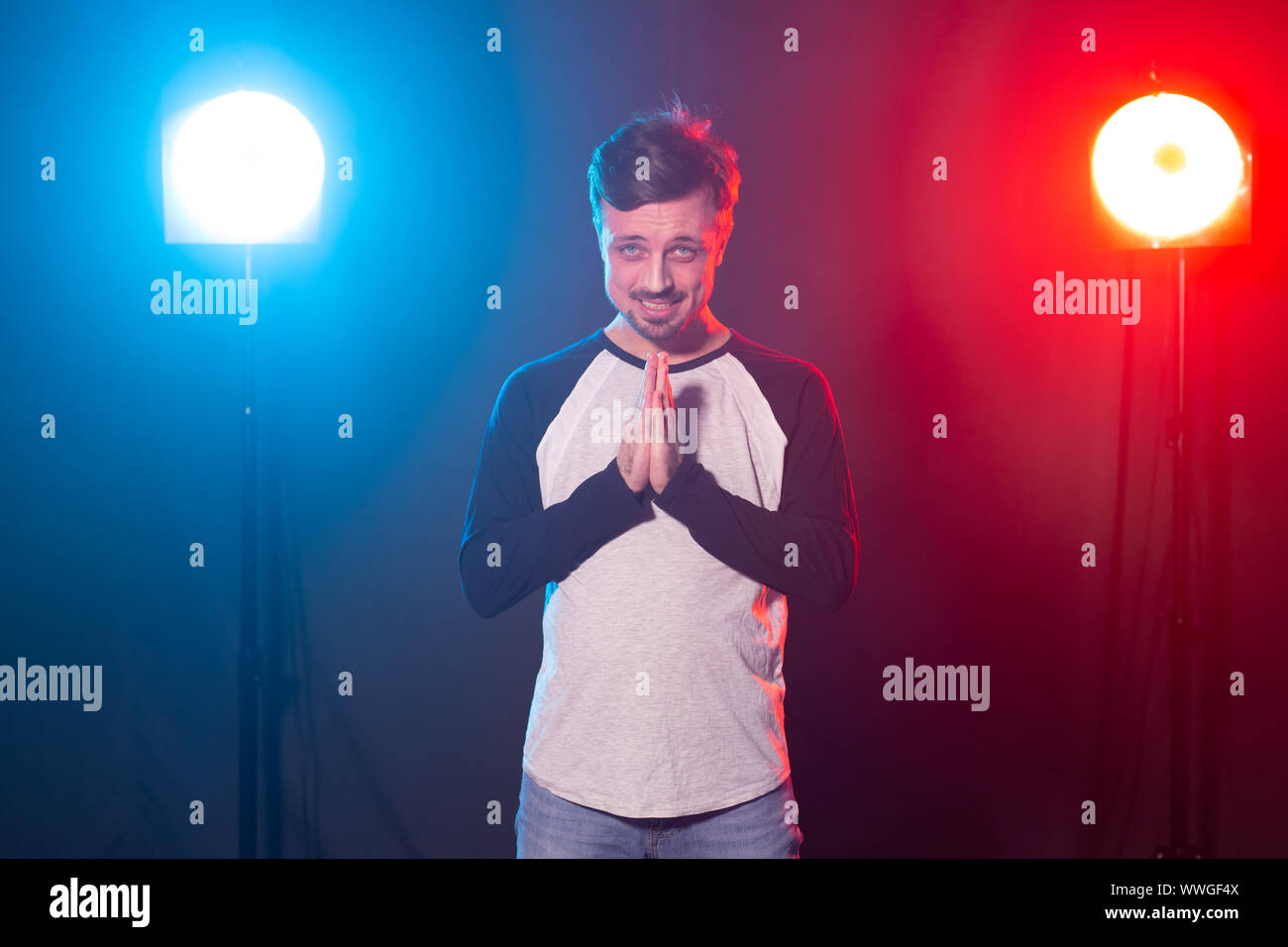 Portrait of man keeps palms together, has pleased expression. Glad ...