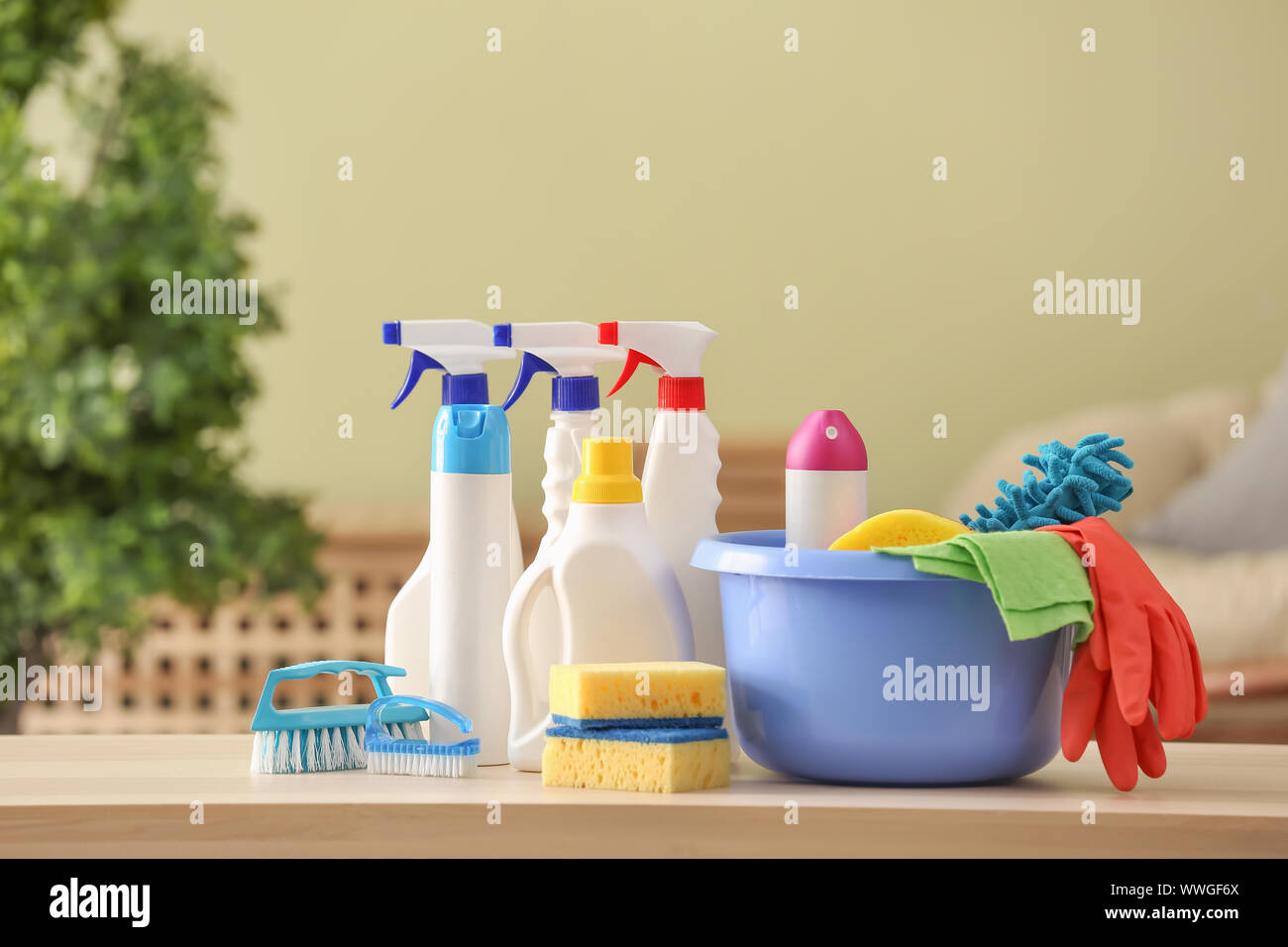 Set of cleaning supplies on table in room Stock Photo - Alamy