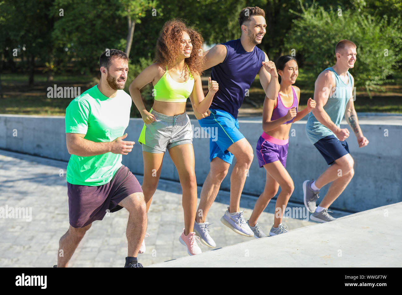 Group of young sporty people running together outdoors Stock Photo - Alamy