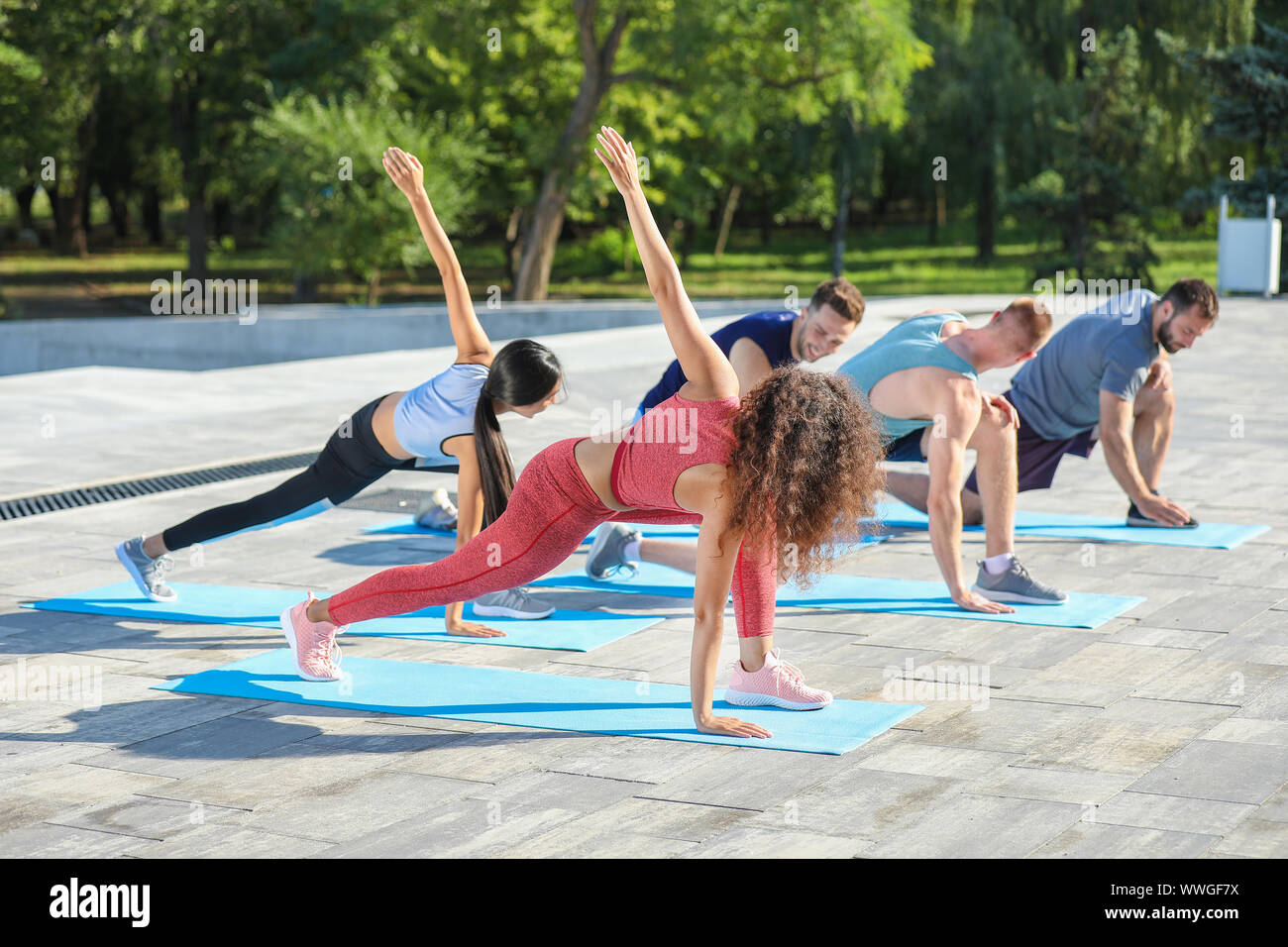 Group of young sporty people training together outdoors Stock Photo - Alamy