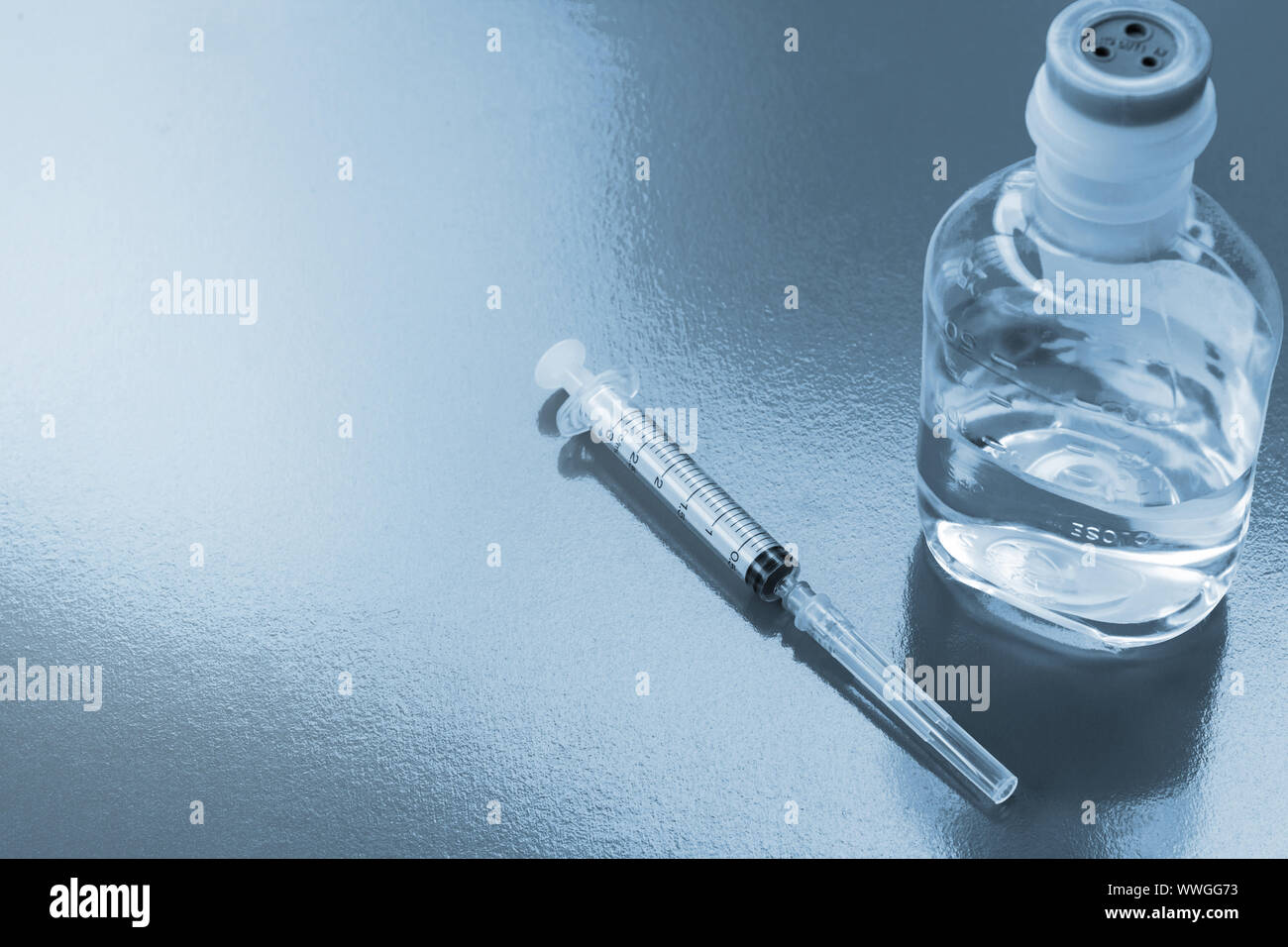 Syringe or injection needle on blue background, medical and health care ...