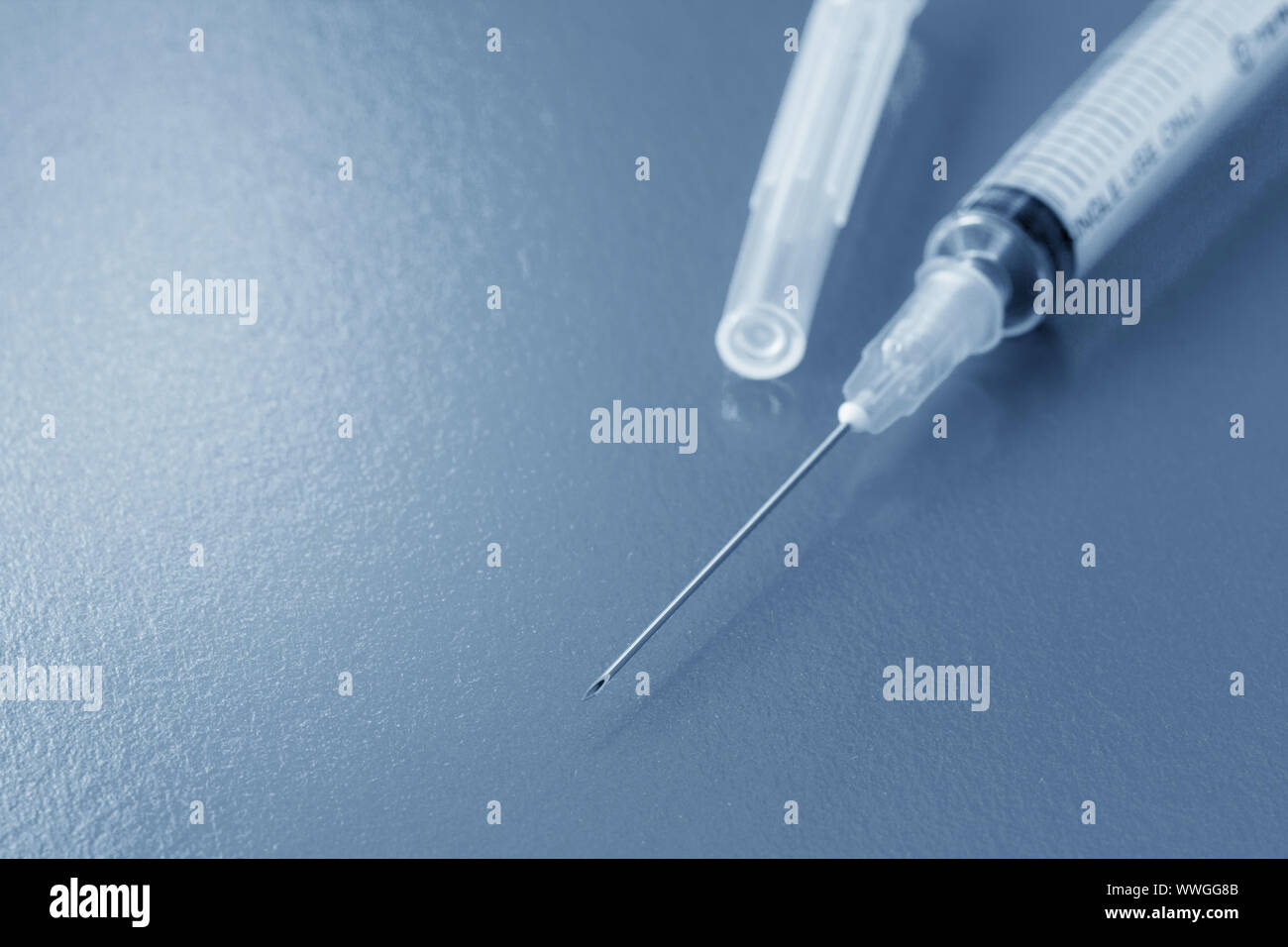 Syringe or injection needle on blue background, medical and health care ...