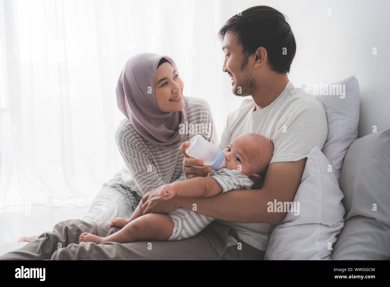 muslim parent feed baby boy with milk on the bottle Stock Photo - Alamy