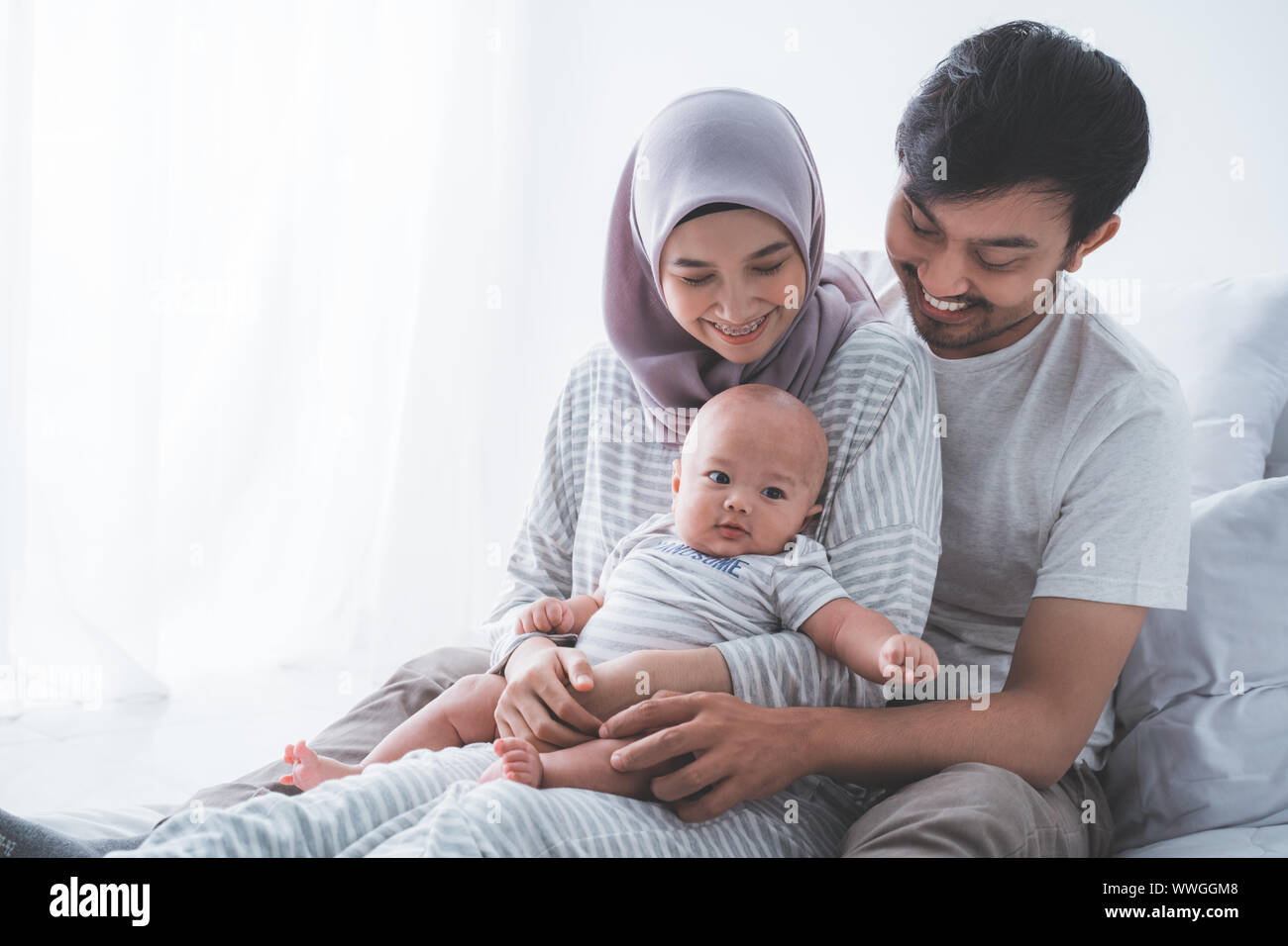 muslim parent with baby boy on the bed having fun Stock Photo - Alamy