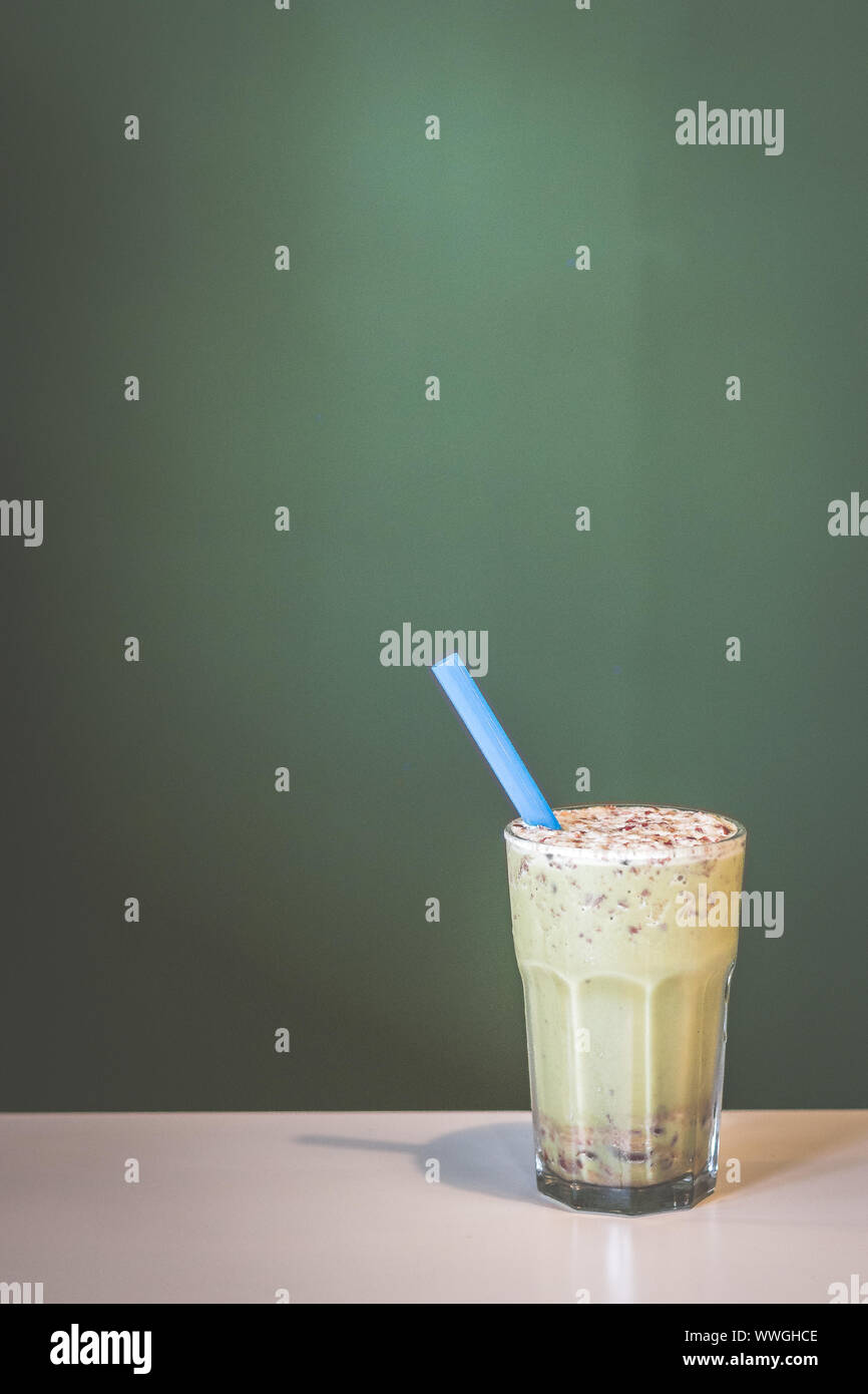 Matcha green tea red bean latte blended with ice and served in a tall ...