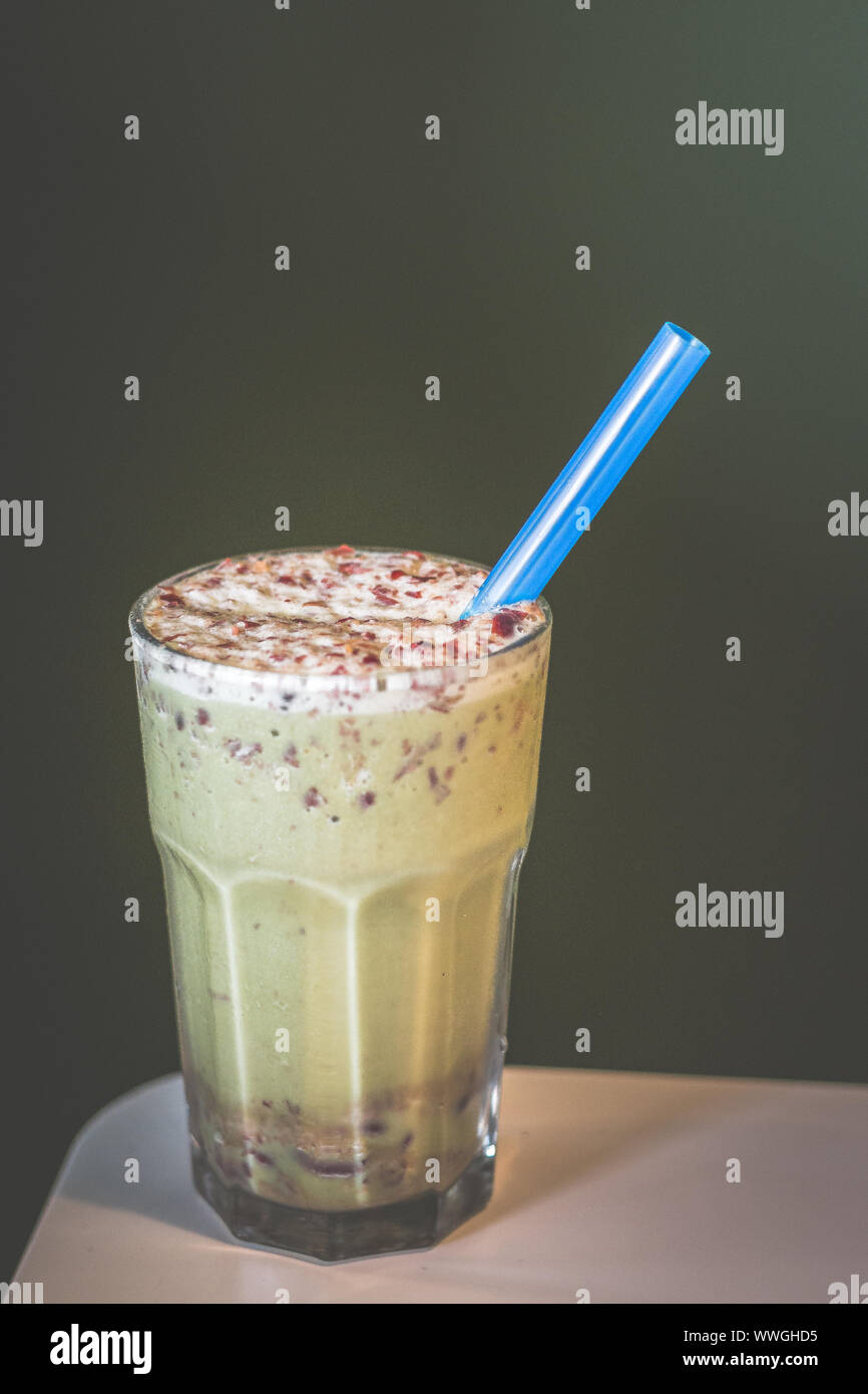 Matcha green tea red bean latte blended with ice and served in a tall ...