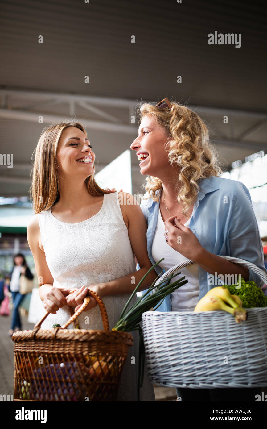 Young women friends baying vegetables and fruits on the market Stock ...