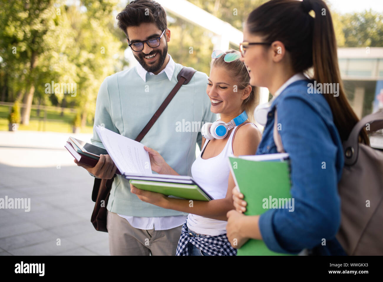 Happy university friends studying together in college Stock Photo - Alamy