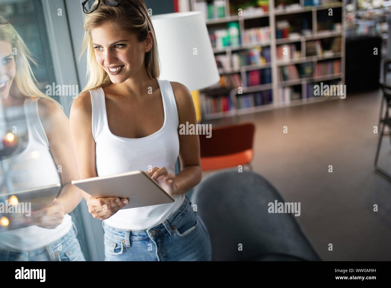Beautiful happy student woman studying in library Stock Photo - Alamy