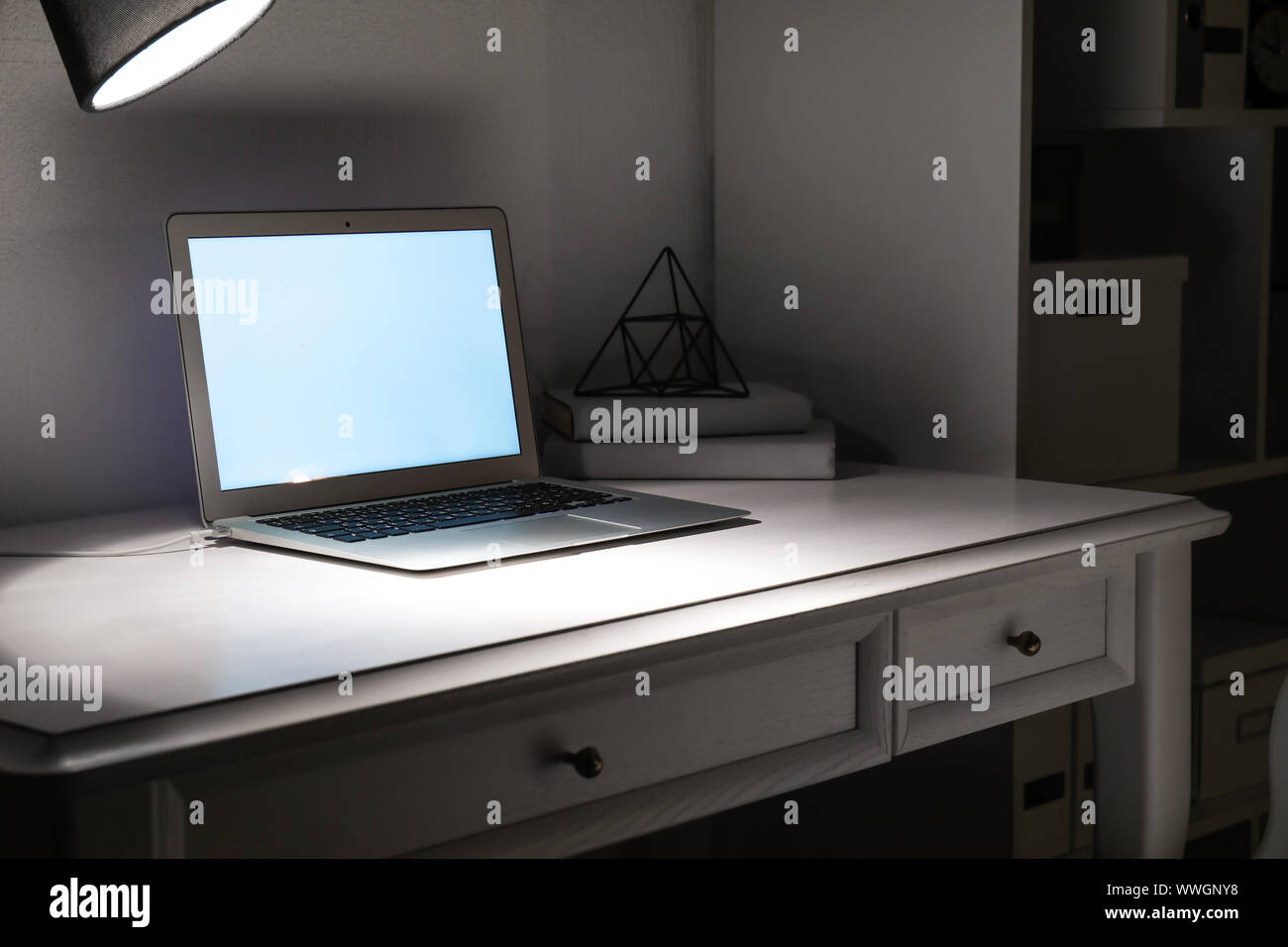 Modern workplace with laptop in evening Stock Photo - Alamy