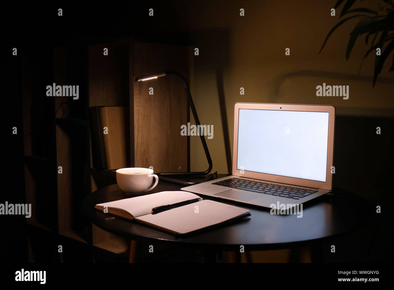 Modern workplace with laptop in evening Stock Photo - Alamy
