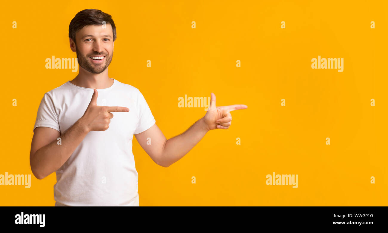 Positive Man Pointing Fingers Aside In Studio, Panorama Stock Photo - Alamy