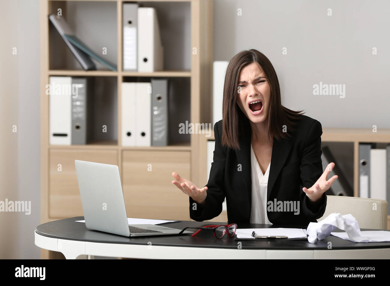 Stressed young woman at workplace in office Stock Photo - Alamy