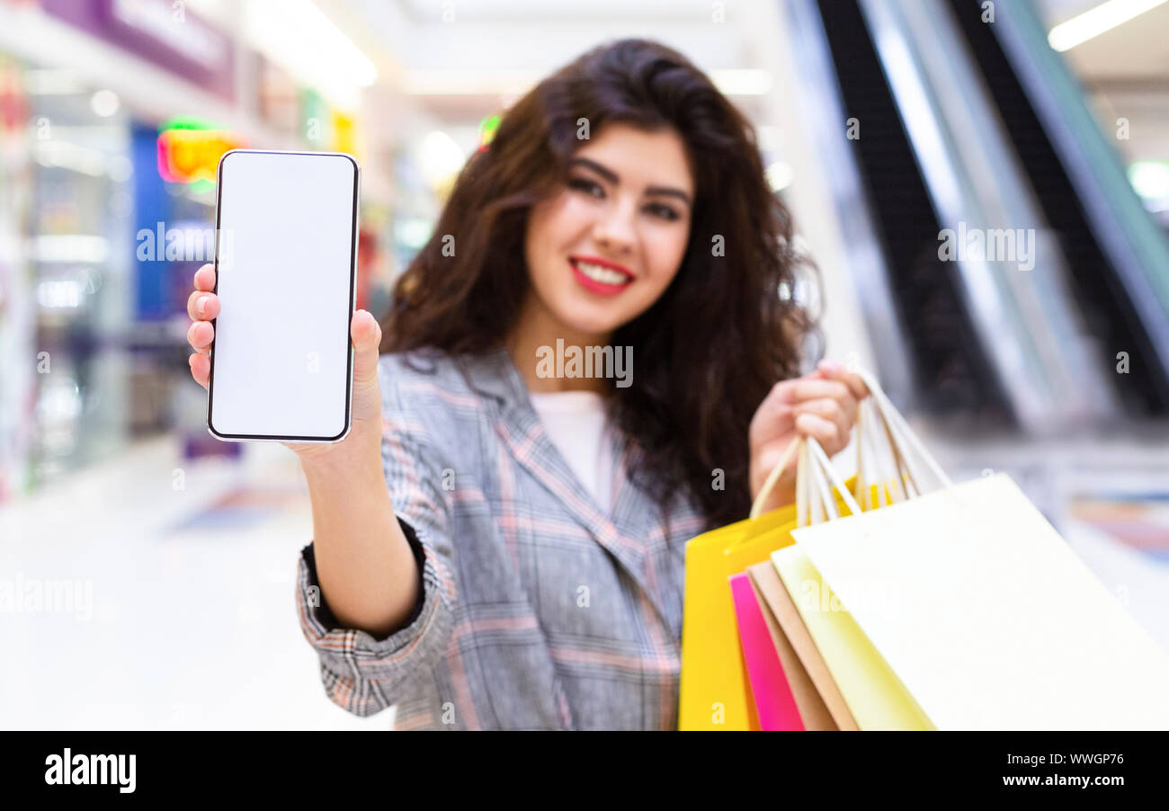 Girl showing cellphone after shopping in big mall Stock Photo - Alamy
