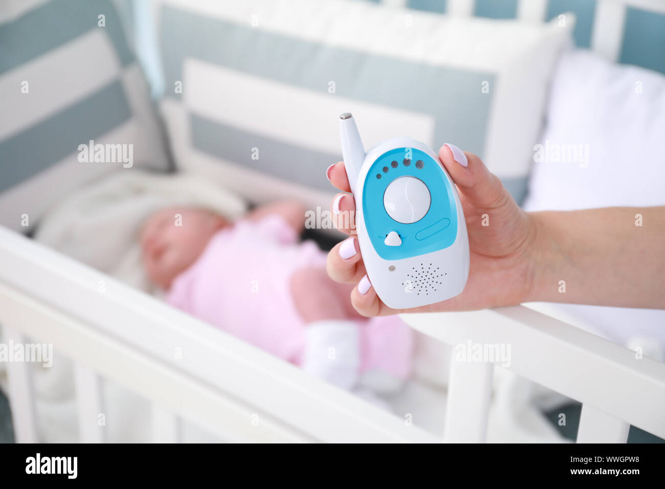 Mother holding radio nanny near bed with sleeping baby Stock Photo - Alamy