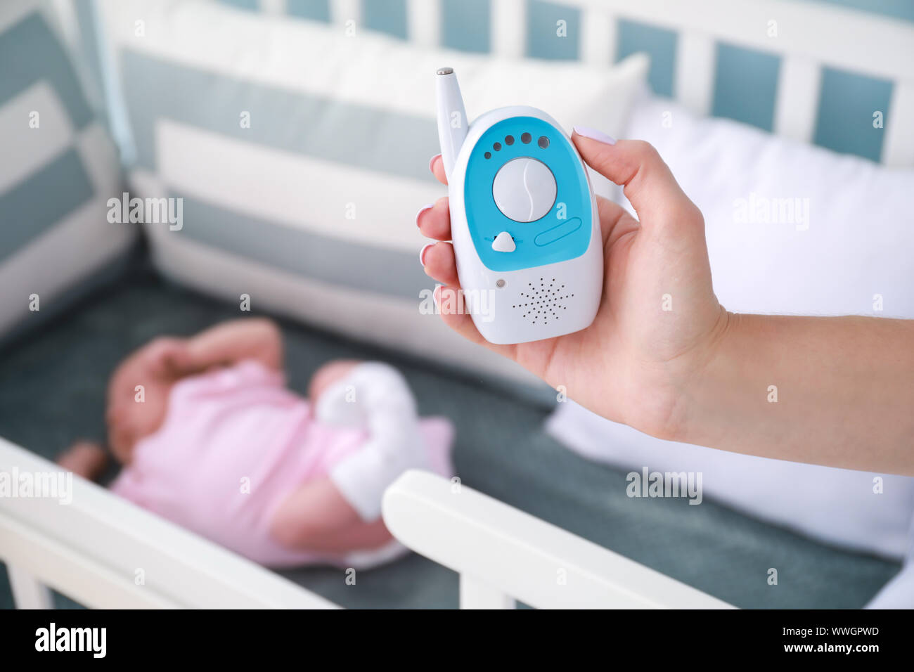 Mother holding radio nanny near bed with sleeping baby Stock Photo - Alamy