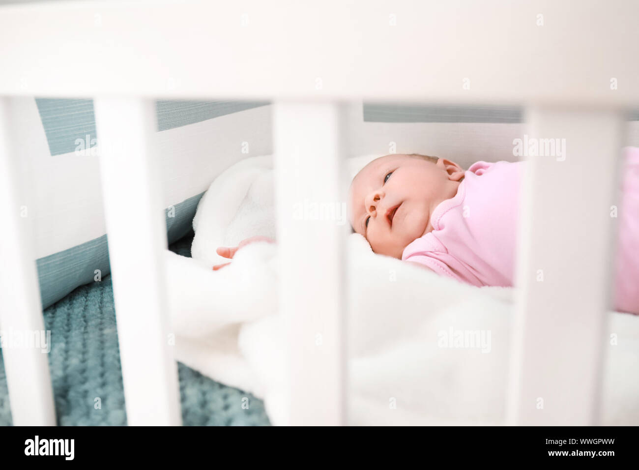 Cute little baby lying in crib Stock Photo - Alamy