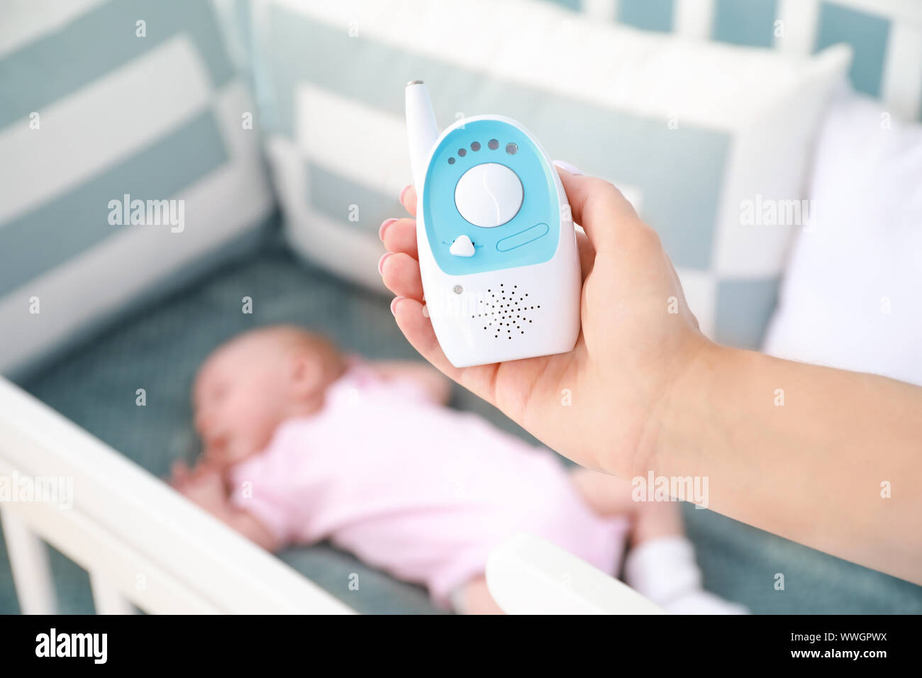 Mother holding radio nanny near bed with sleeping baby Stock Photo - Alamy