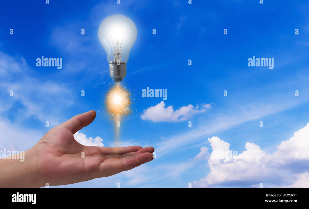 Business idea concept, light bulb rocket launch on blue sky background ...