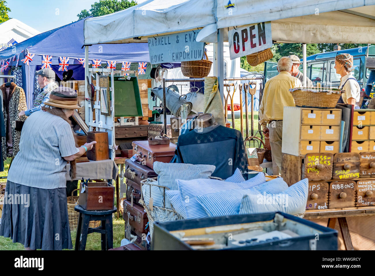 Lady dressed up in 1940s style clothing looking around a vintage stall ...