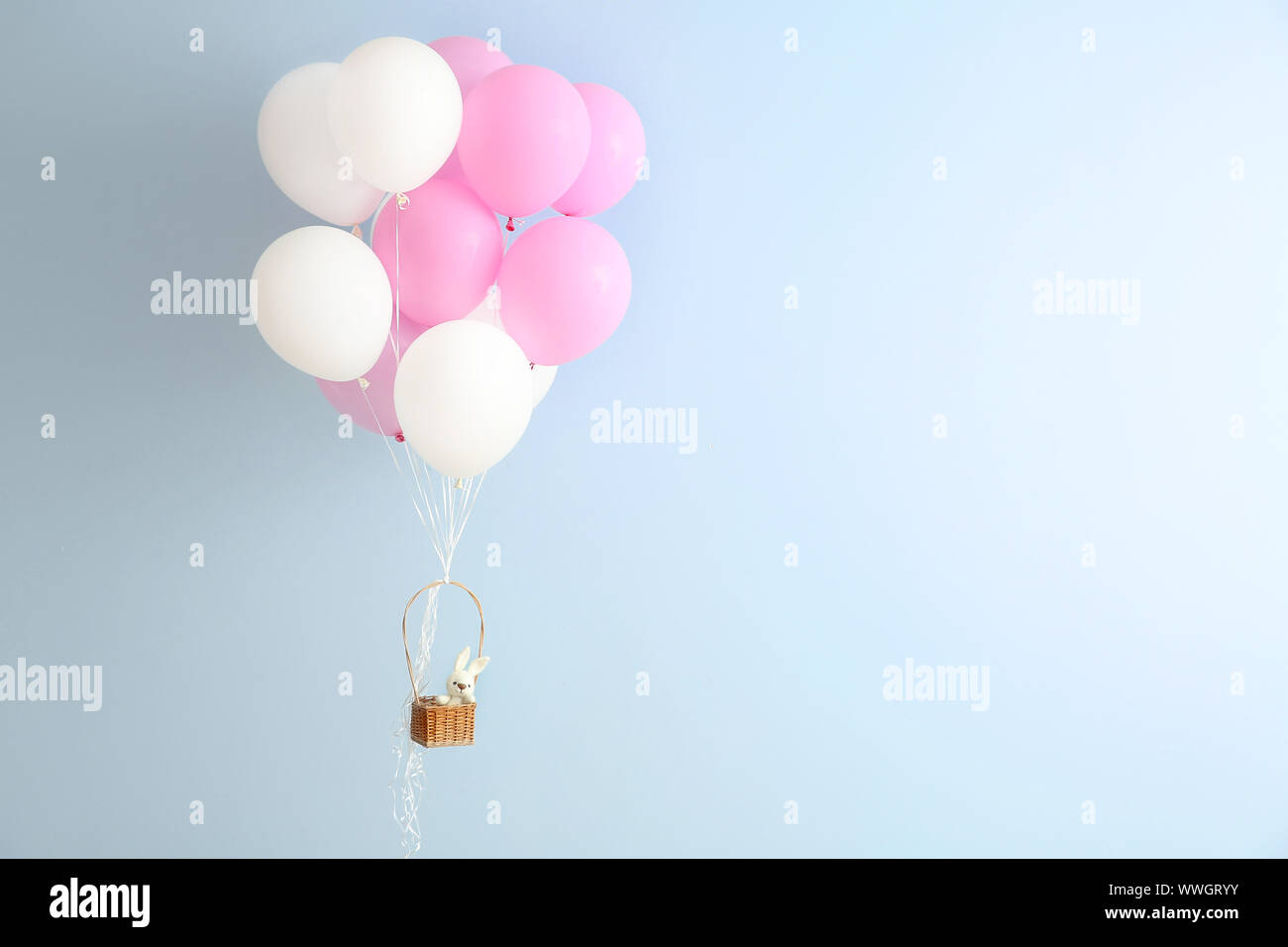 Flying basket with balloons on color background Stock Photo - Alamy