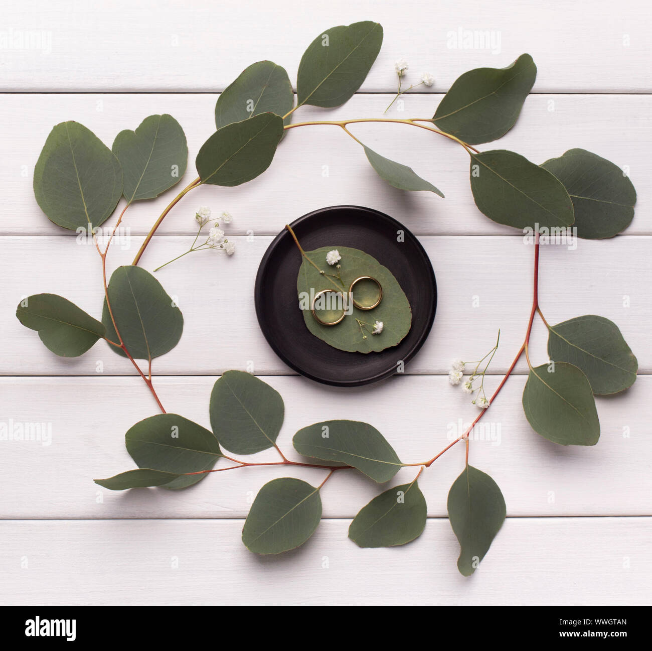 Top view of wedding ring composition on white wooden table Stock Photo ...