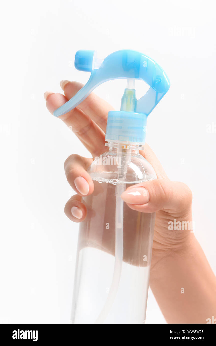 Female hand with bottle of air freshener on light background Stock ...