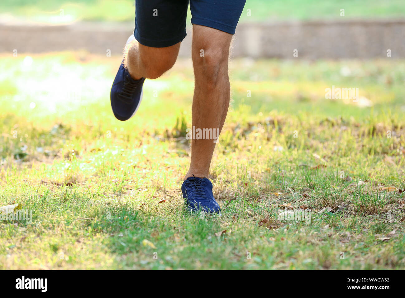 Handsome sporty man running in park Stock Photo - Alamy