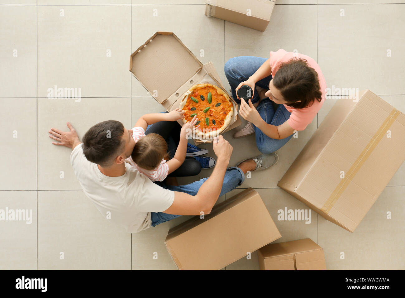 Happy family eating pizza on moving day Stock Photo - Alamy