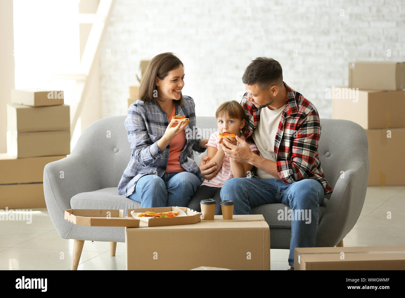 Happy family eating pizza on moving day Stock Photo - Alamy